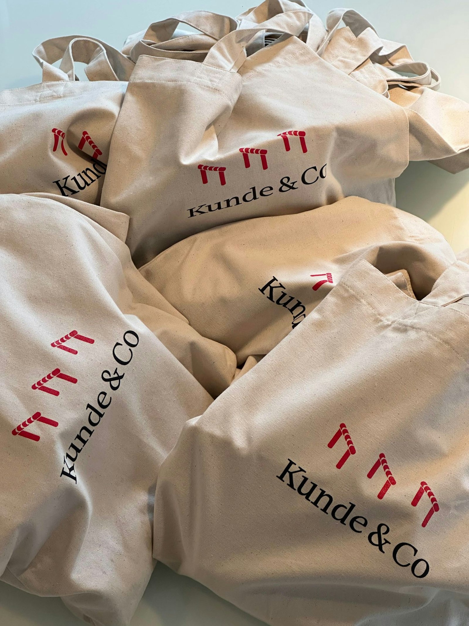 Custom branded tote bags by Kunde & Co for company merchandise